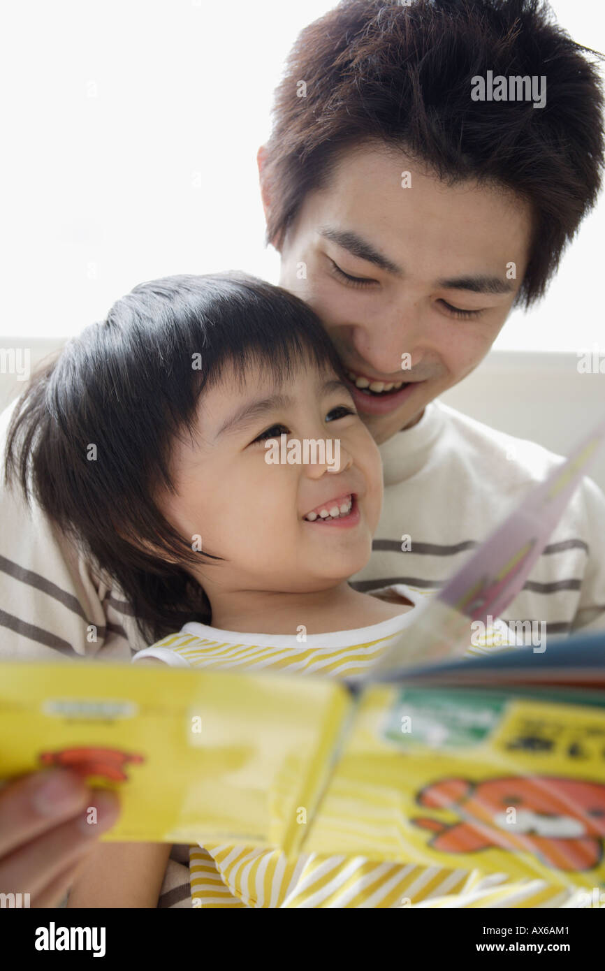 A young father reading a book to his son Stock Photo - Alamy