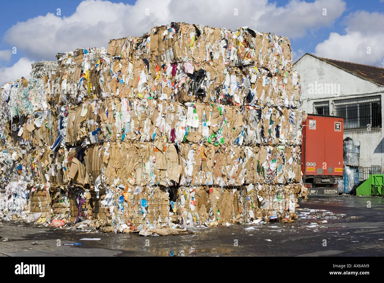 Bales of waste paper and cardboard cartons stacked awaiting recycling ...