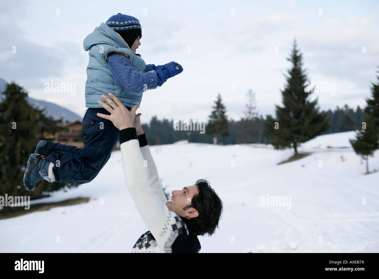 Young man tossing son above head Stock Photo - Alamy
