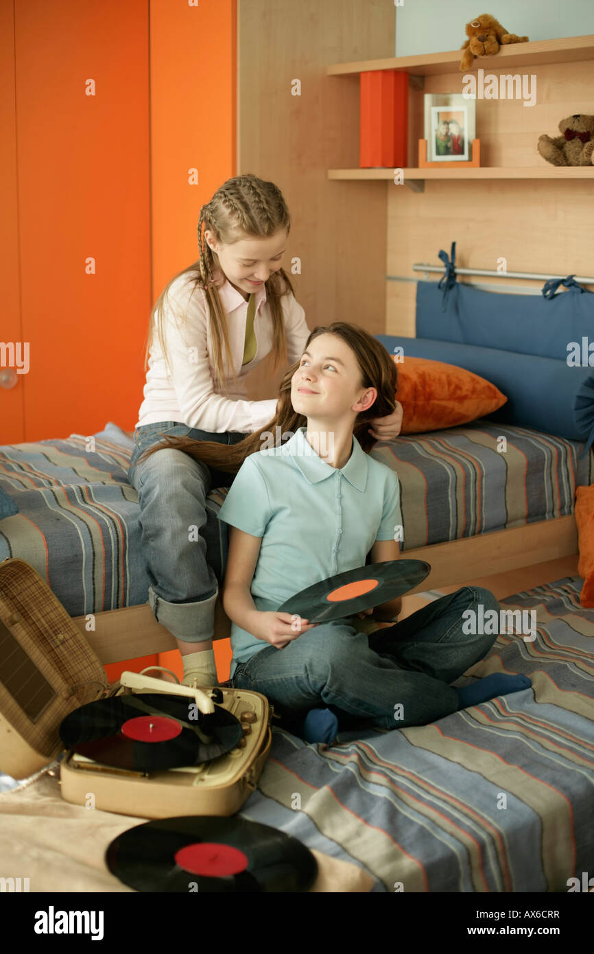 Two friends listening to music of a record player Stock Photo - Alamy