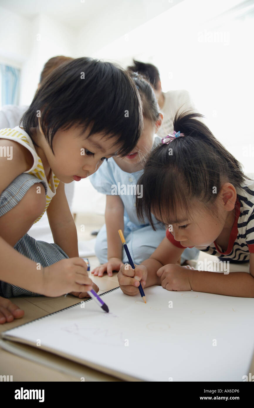 Three children drawing pictures Stock Photo - Alamy