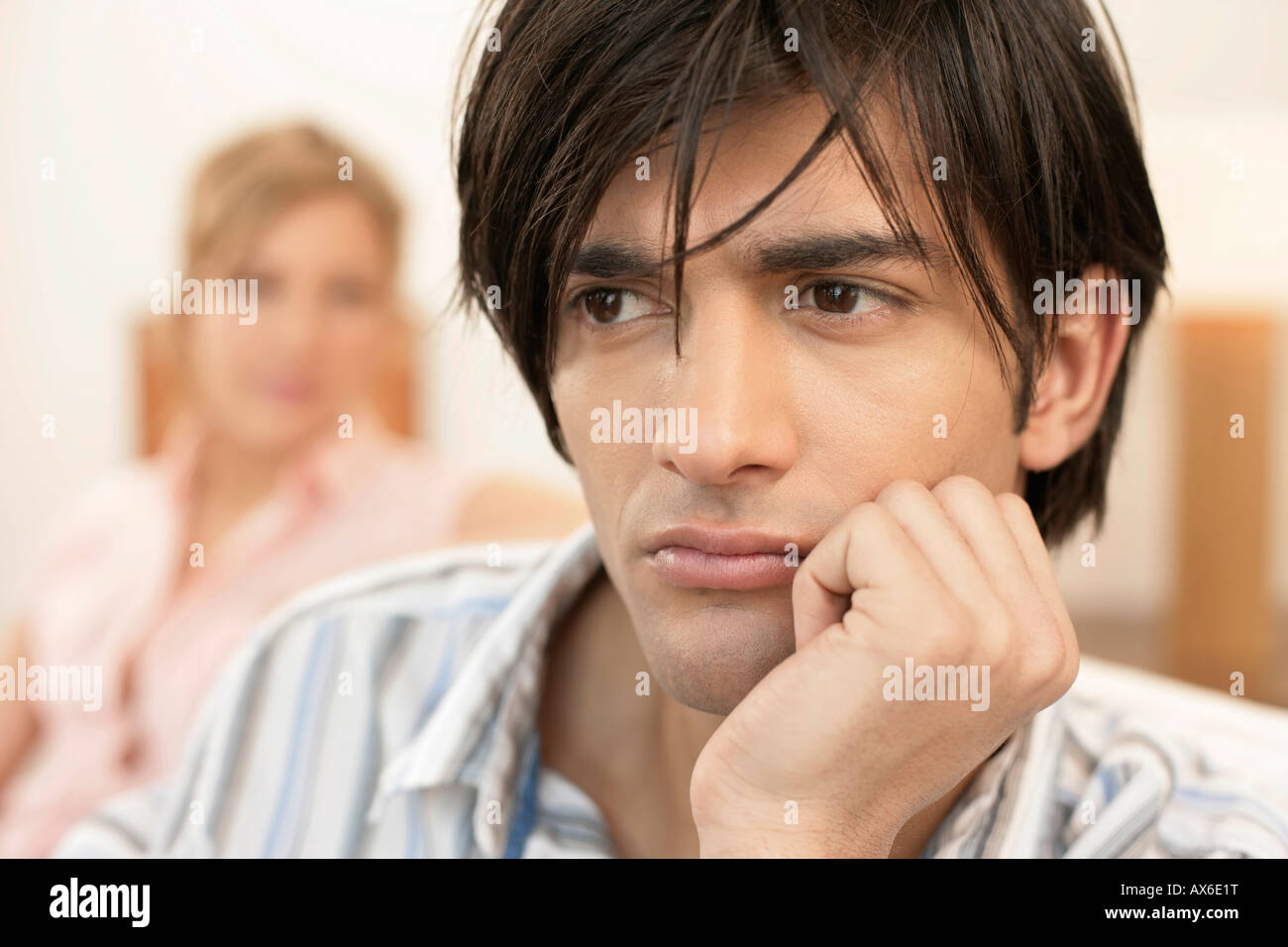 Dissatisfied young man, woman sitting in background Stock Photo - Alamy