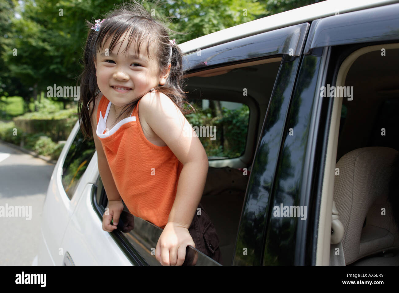 A girl leaning forward from a car window Stock Photo - Alamy
