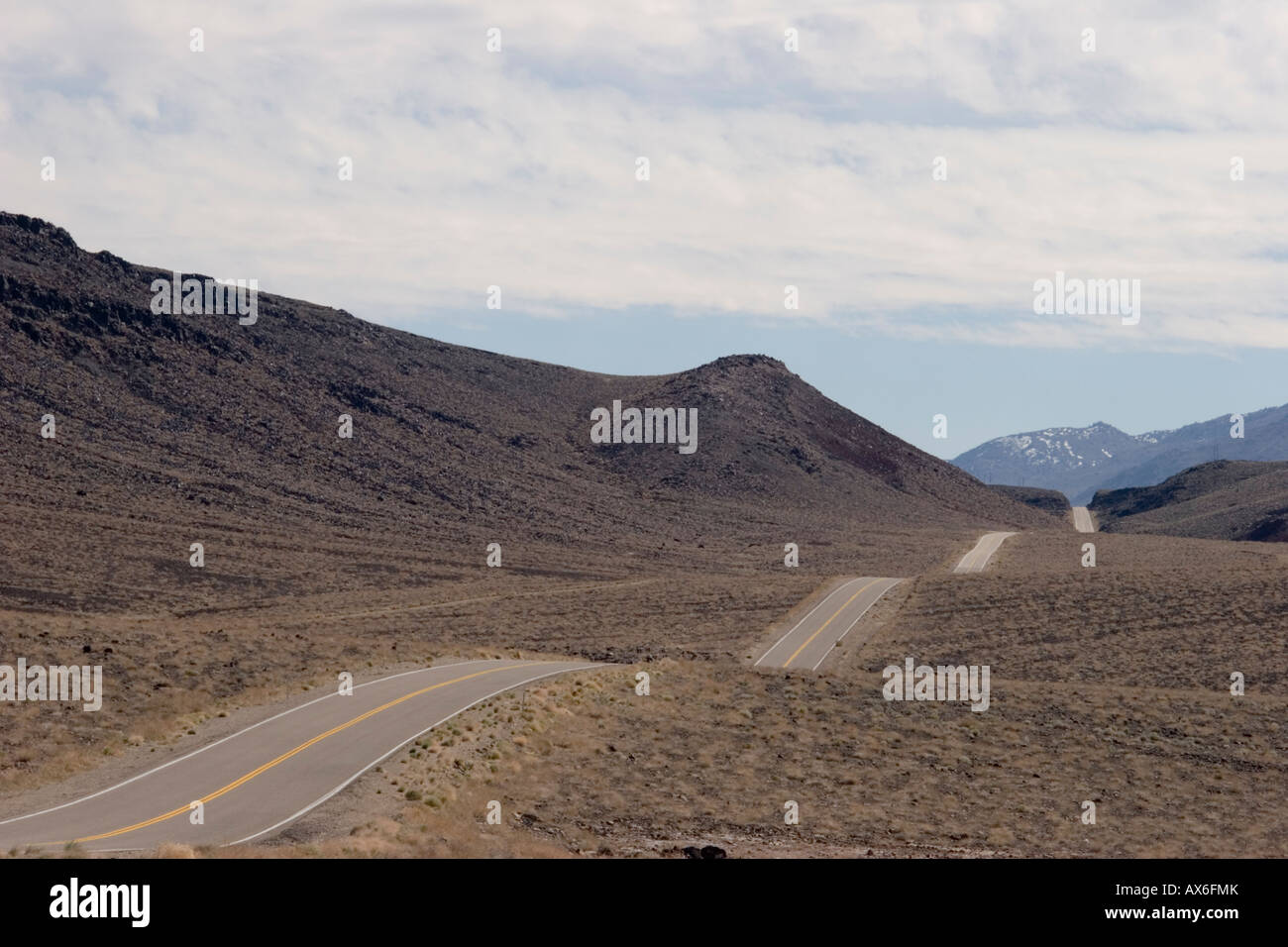 Two-lane desert road traverses rolling hills in Inyo County, California ...