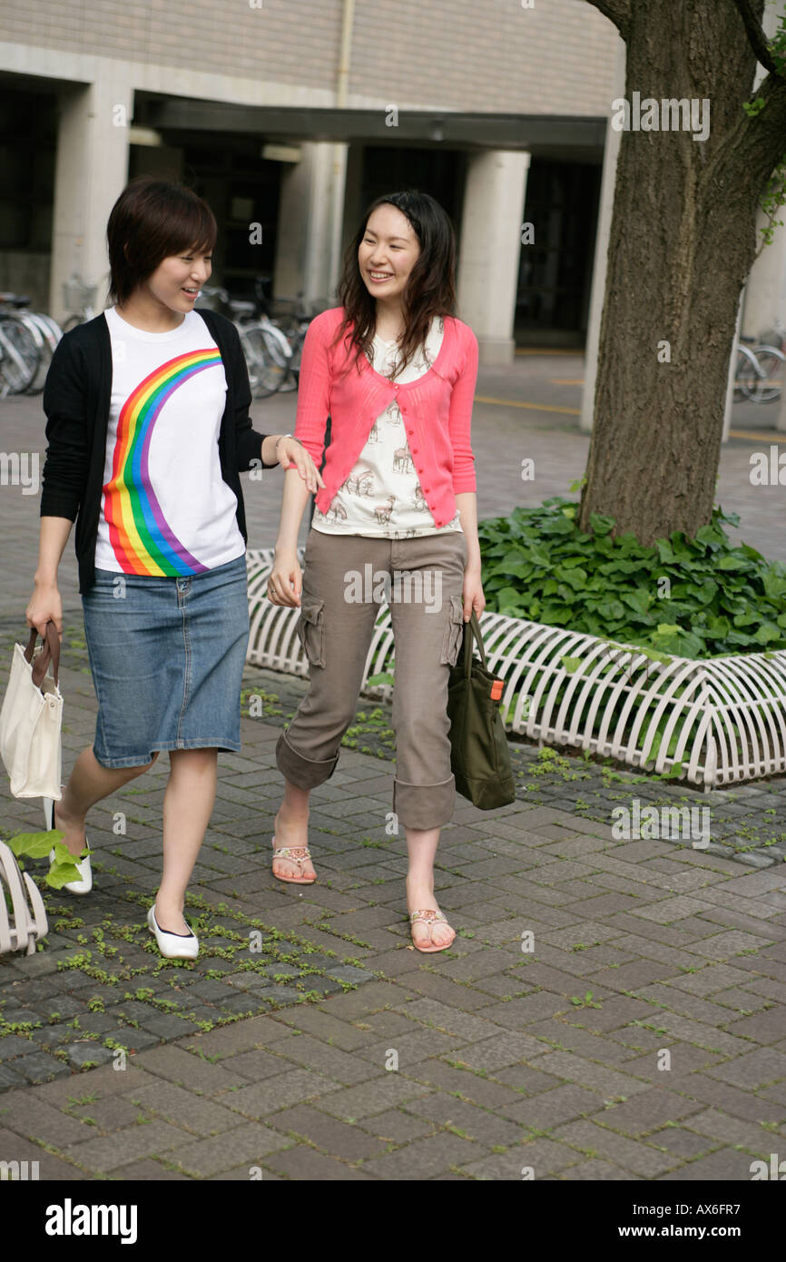 Two young women walking side-by-side Stock Photo - Alamy