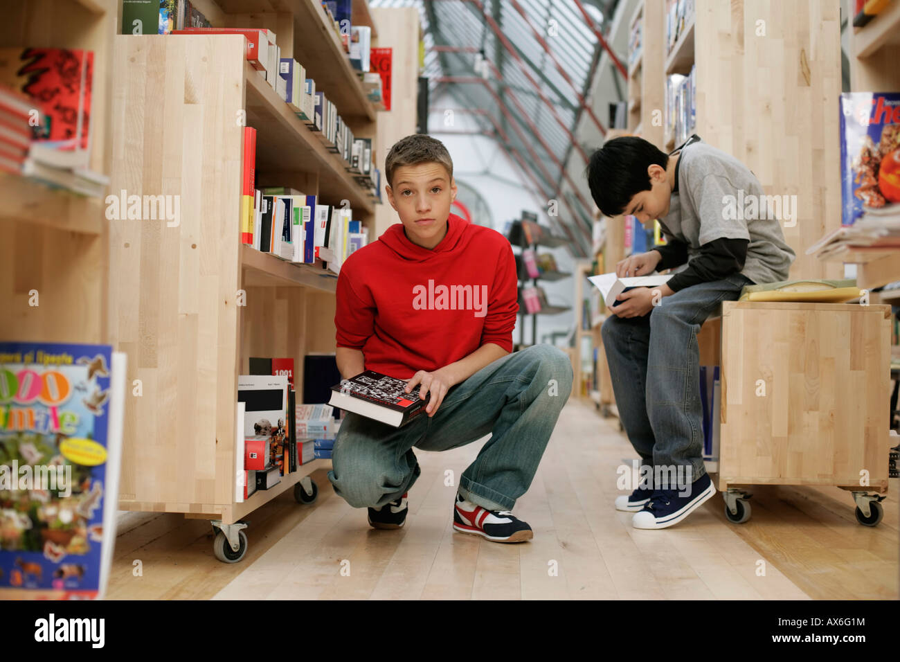Two boys reading inside a library, fully released Stock Photo - Alamy