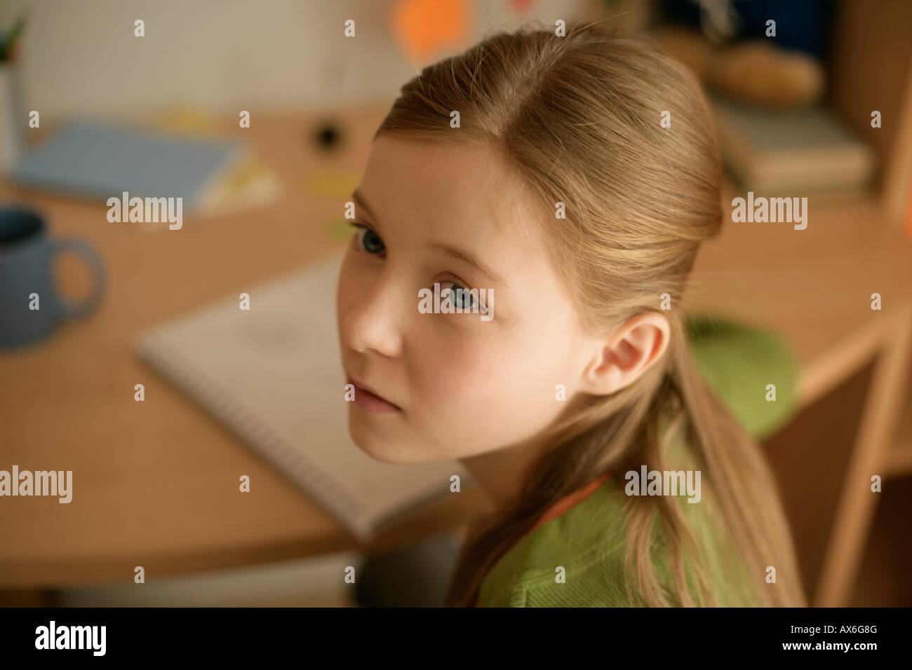 Girl sitting at a desk Stock Photo - Alamy