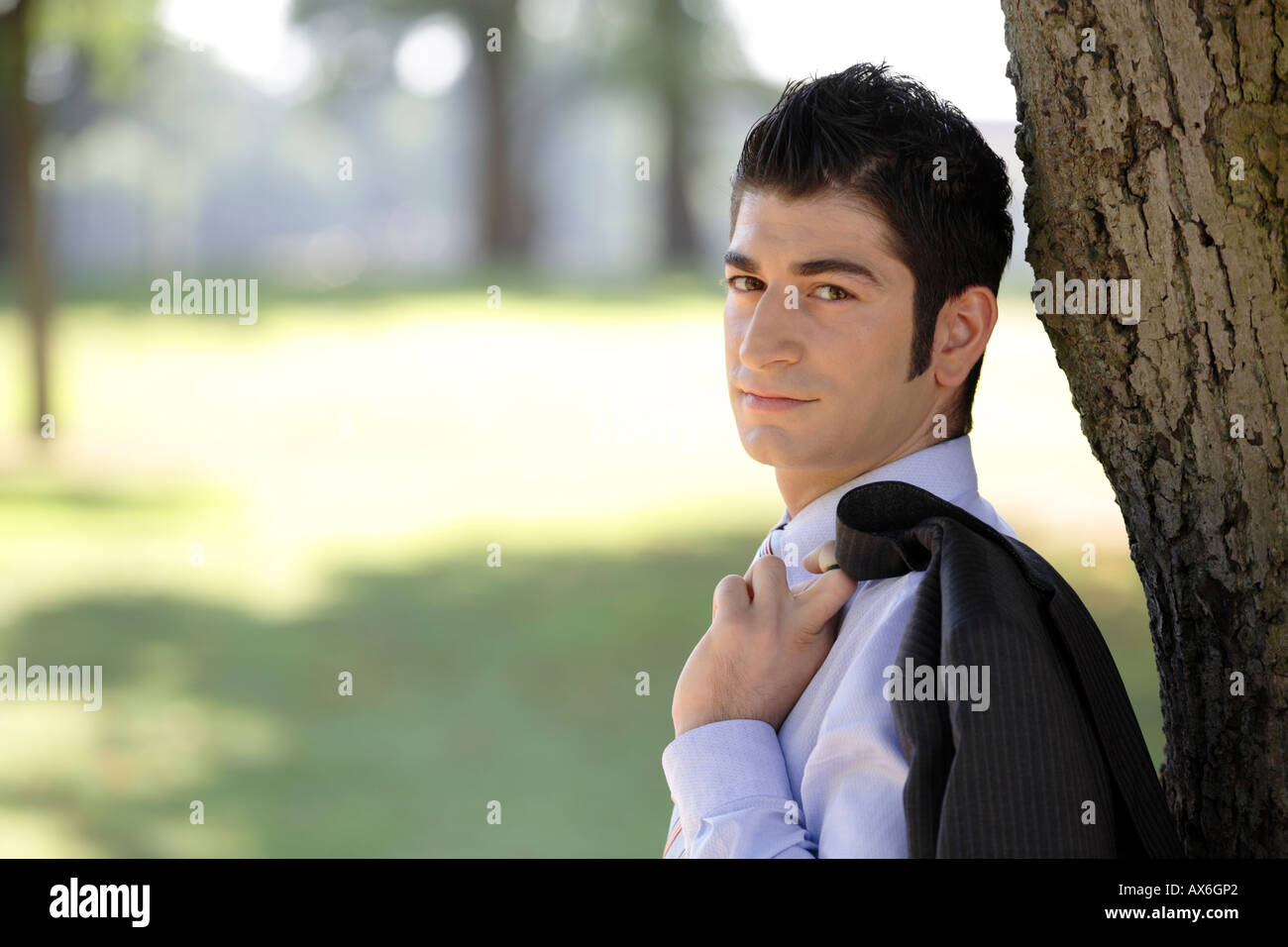portrait of german-turkish groom posing under tree. germany, europe ...