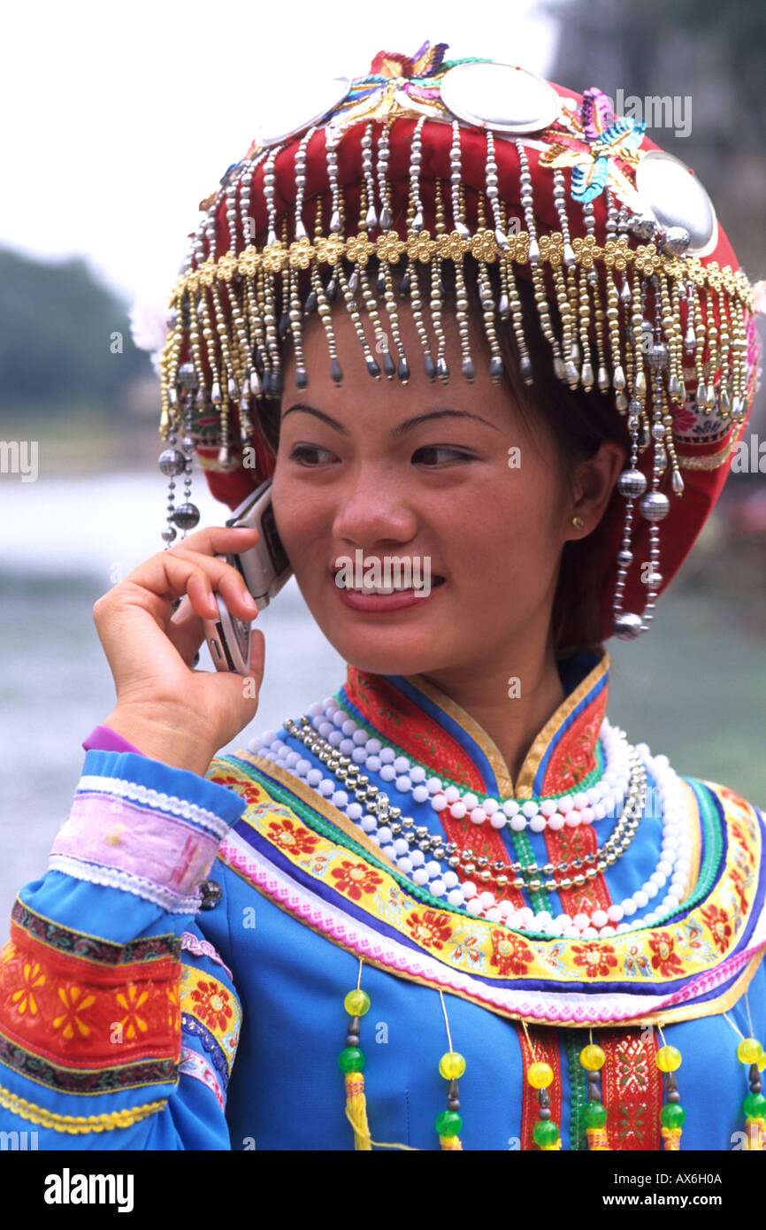 Local woman in traditional costume having communication with cell phone ...