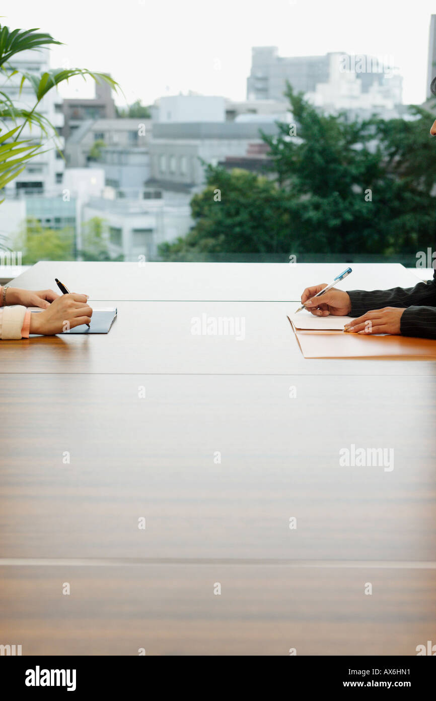 Two people working together on a large wooden table placed in the ...