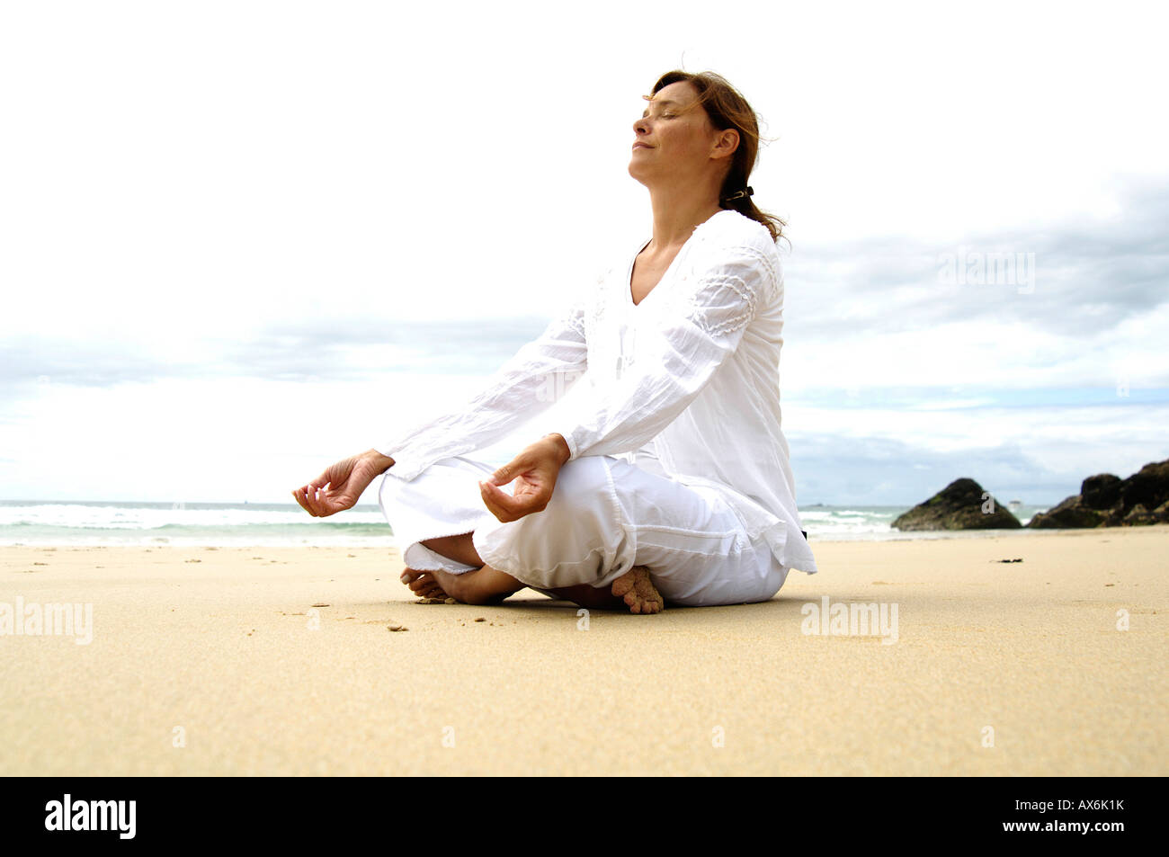 Side profile of woman meditating on beach Stock Photo - Alamy