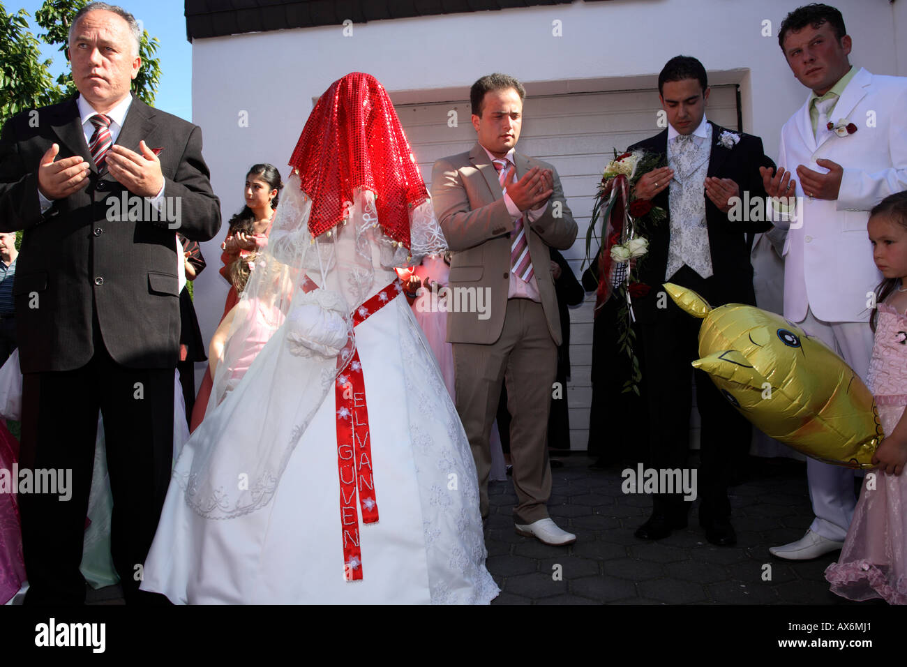 turkish bride and groom are praying together with their families ...