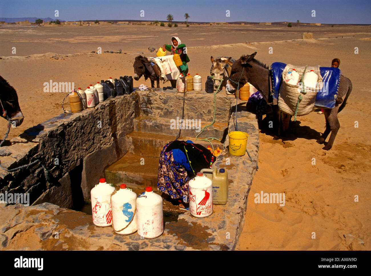 Moroccans, Berbers, girls drawing water from well, town of Merzouga ...