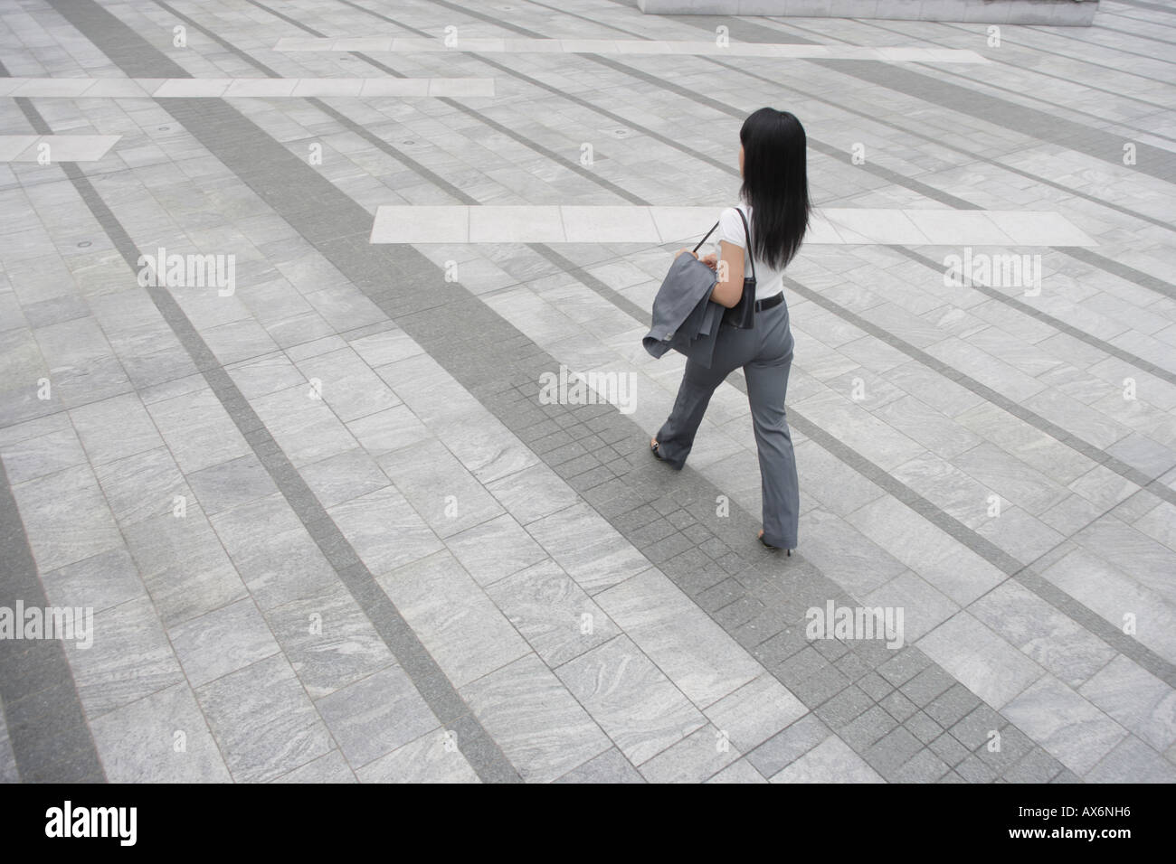 A rear view of a woman walking on a broad pathway Stock Photo - Alamy