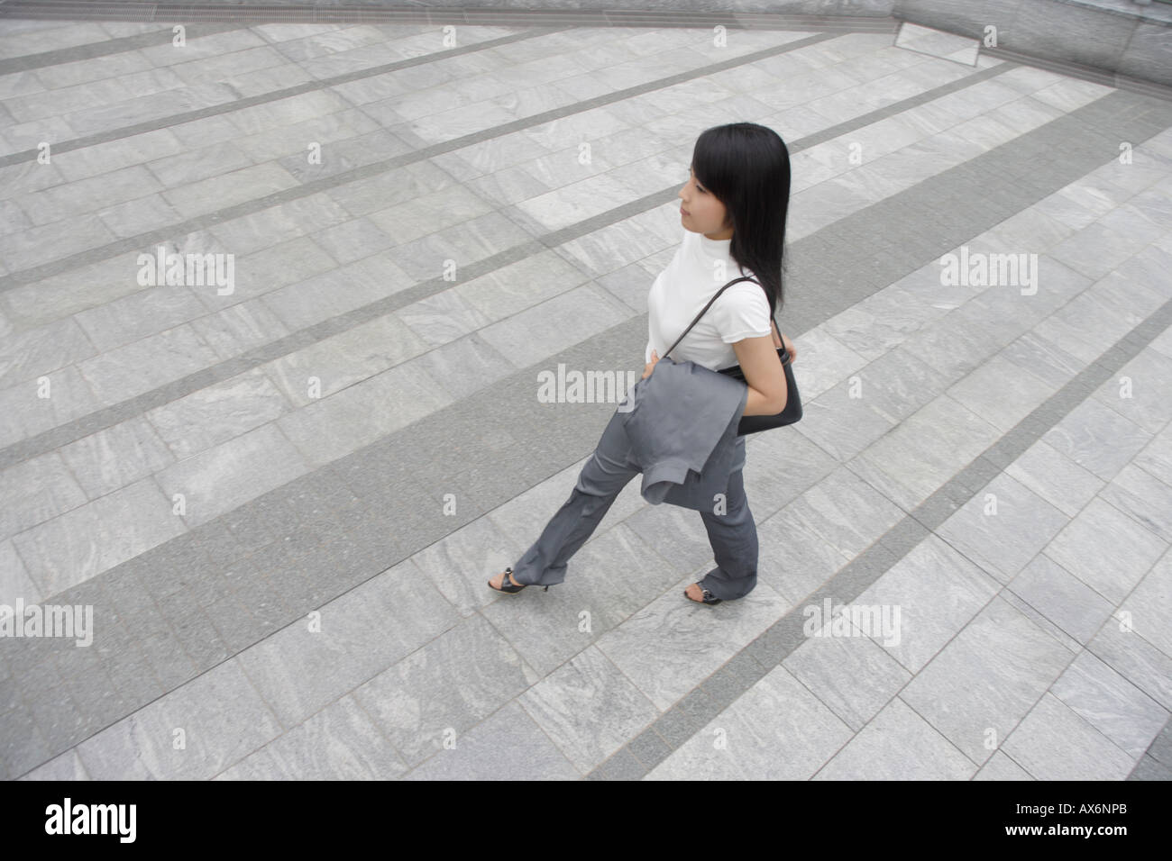 A side view of a woman walking on a broad pathway Stock Photo - Alamy