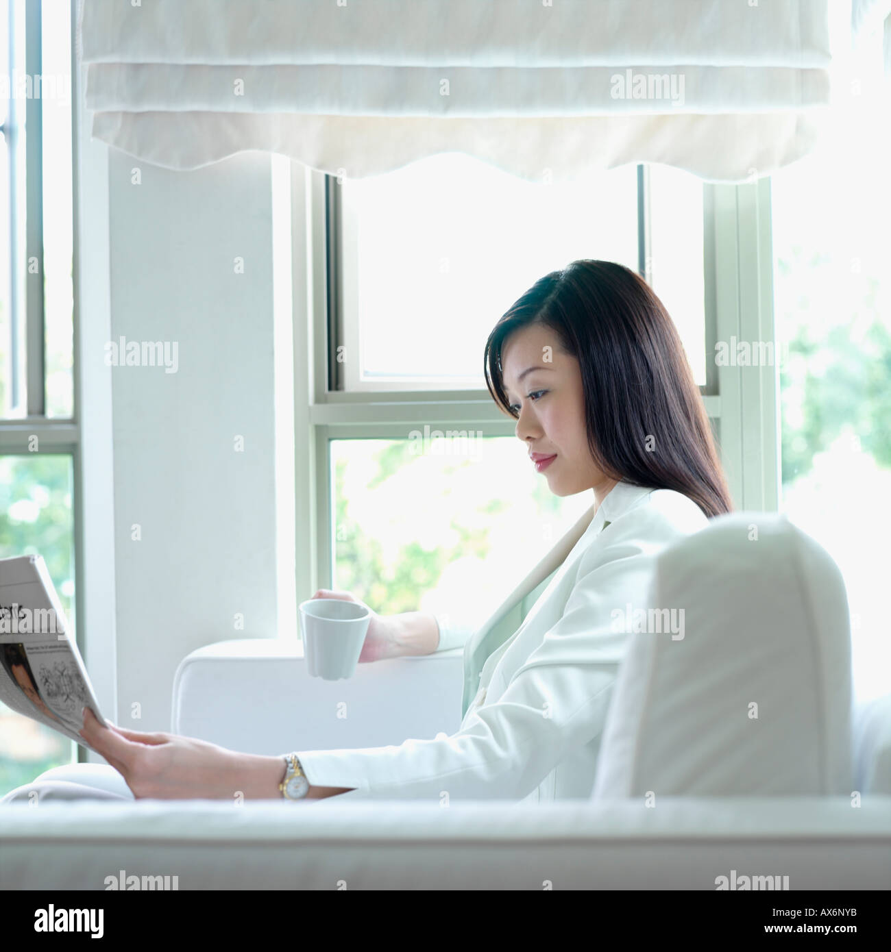 Side profile of a businesswoman reading a newspaper Stock Photo - Alamy