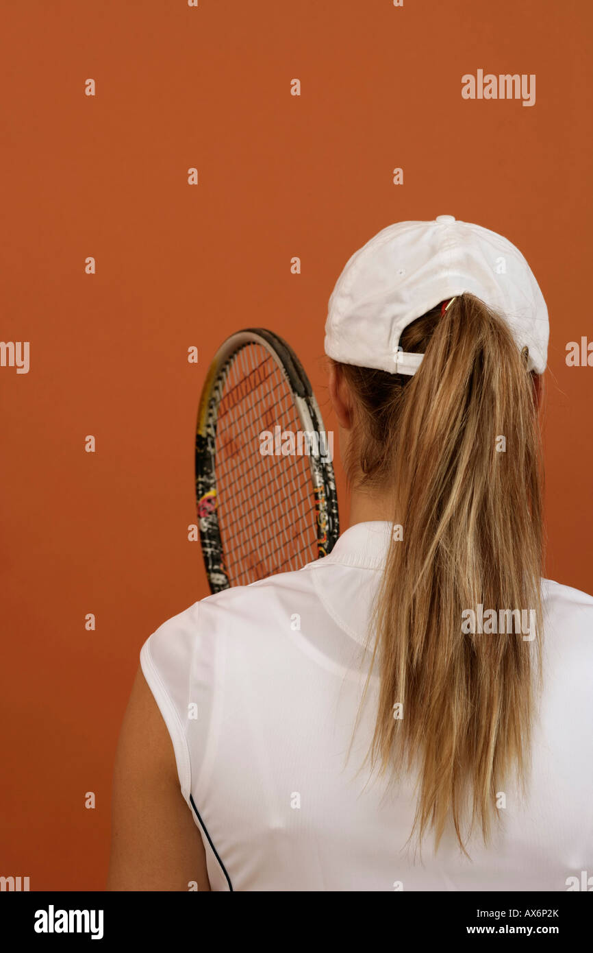 Rear view of a tennis player wearing a cap and holding a racket Stock ...