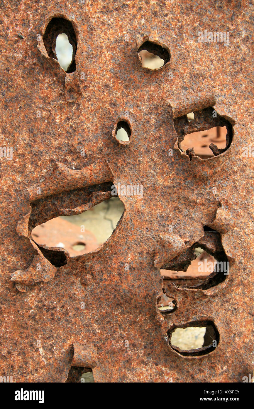 A close-up of fragmentation damage to a metal door at the Saint-Marcouf ...