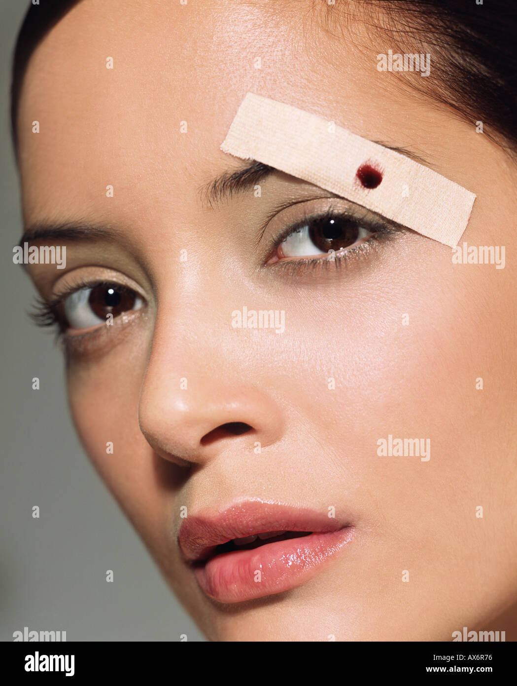 Woman with plaster on her eyebrow Stock Photo - Alamy