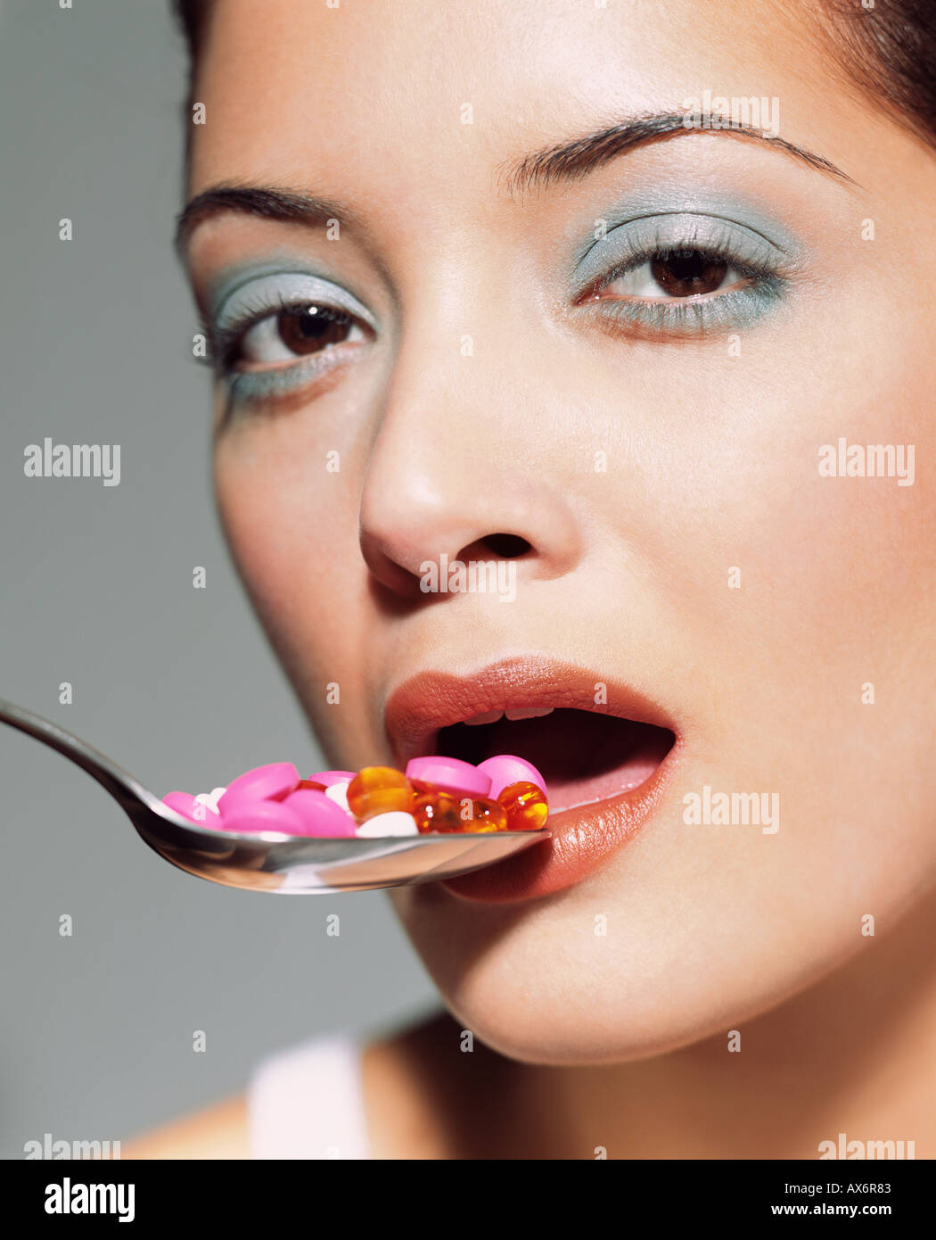 Woman eating spoon of tablets Stock Photo - Alamy