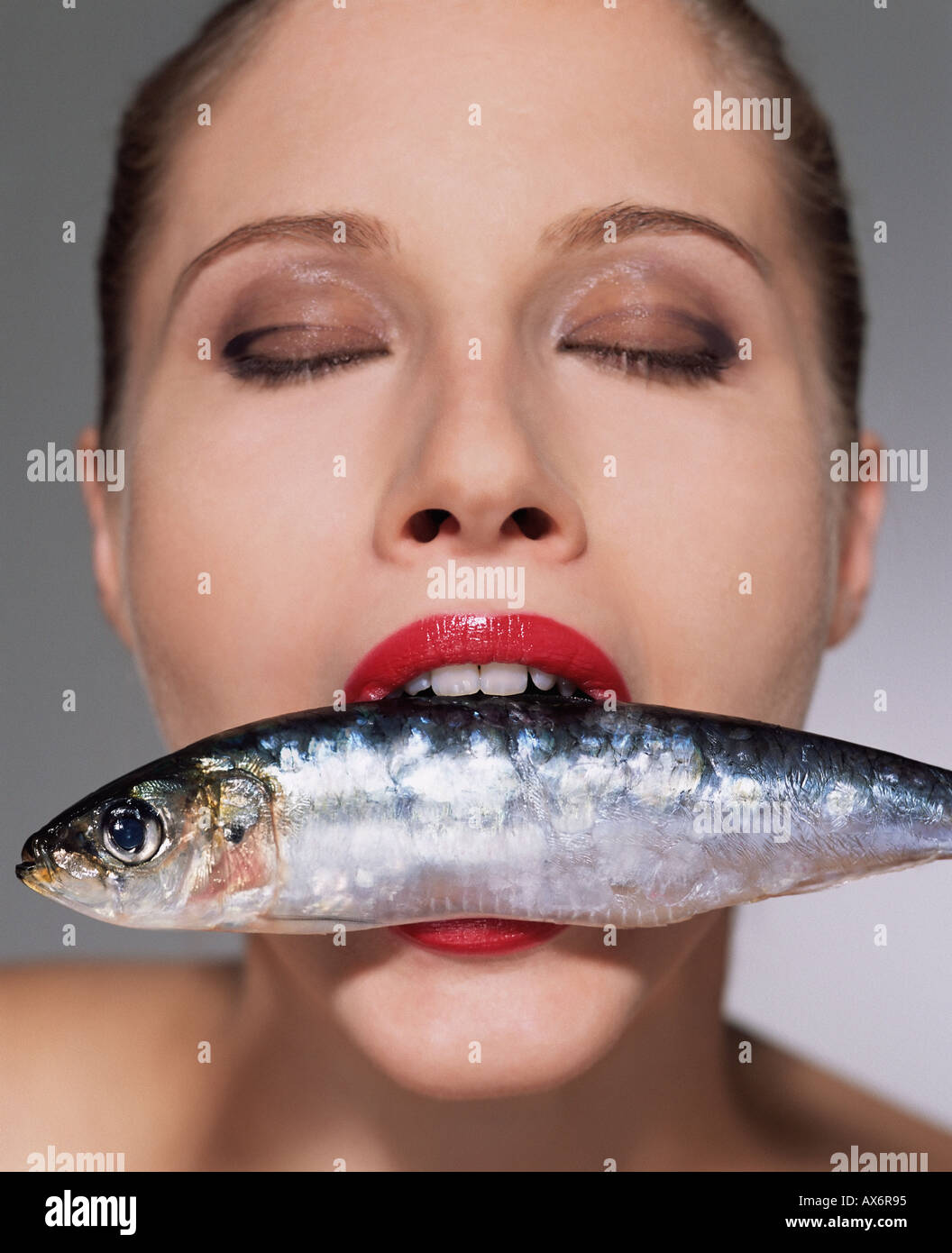 Woman with fish in her mouth Stock Photo - Alamy