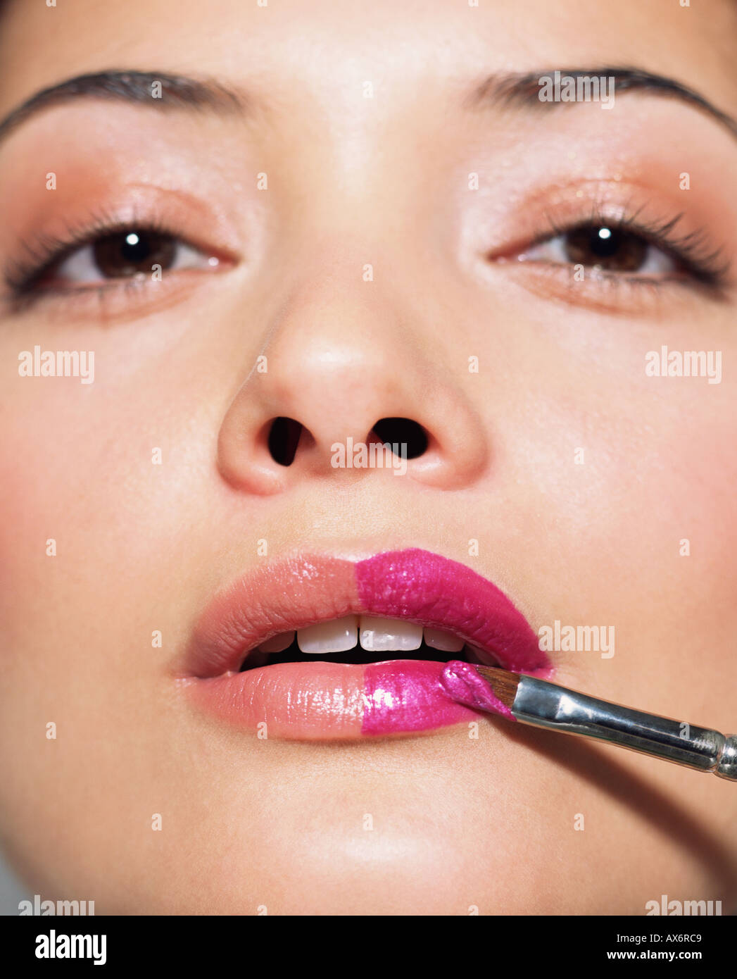 Woman having her mouth painted Stock Photo - Alamy