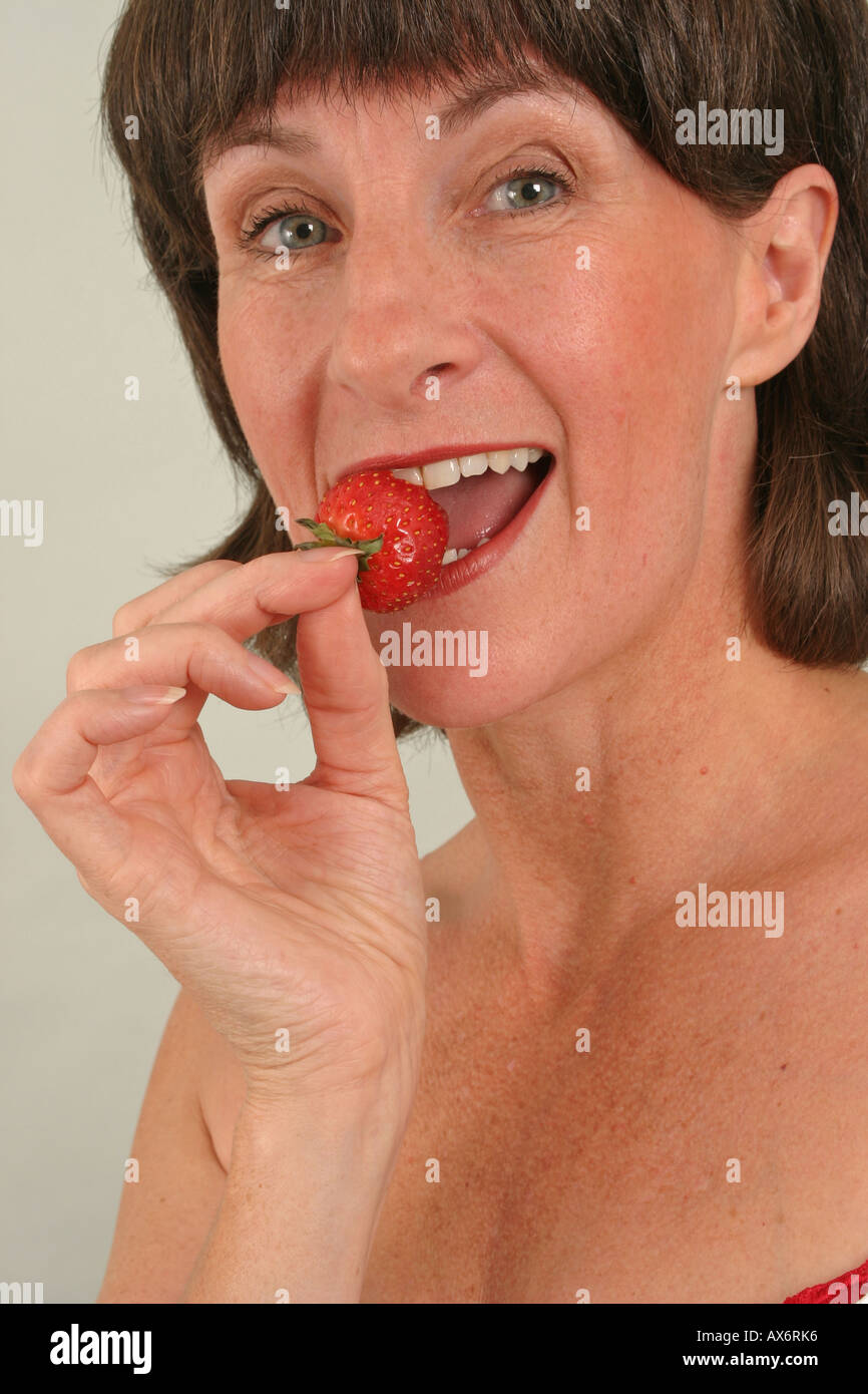 Female eating a strawberry Stock Photo - Alamy