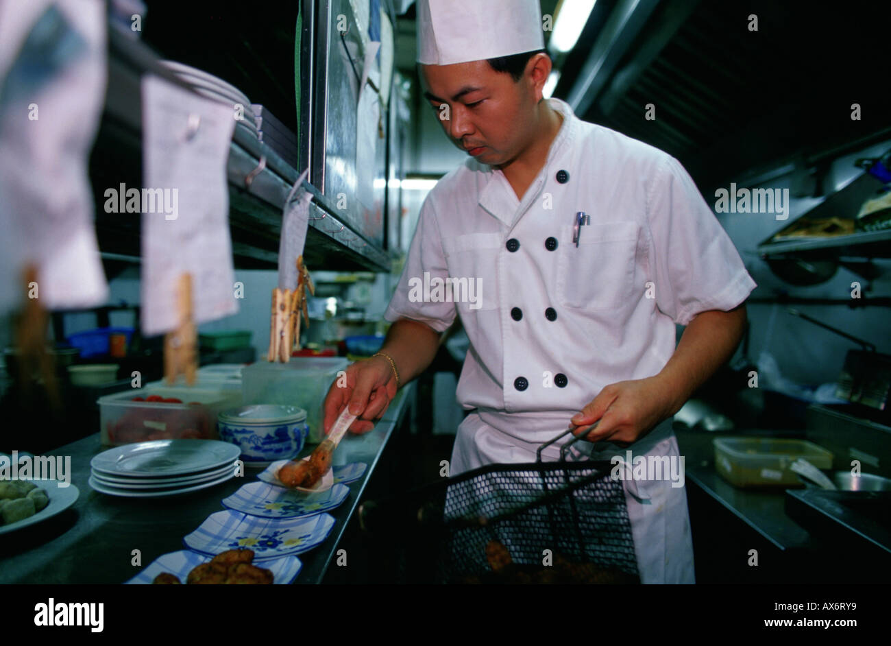 A Chinese chef in a chef hat serves up fritters at a restaurant in ...