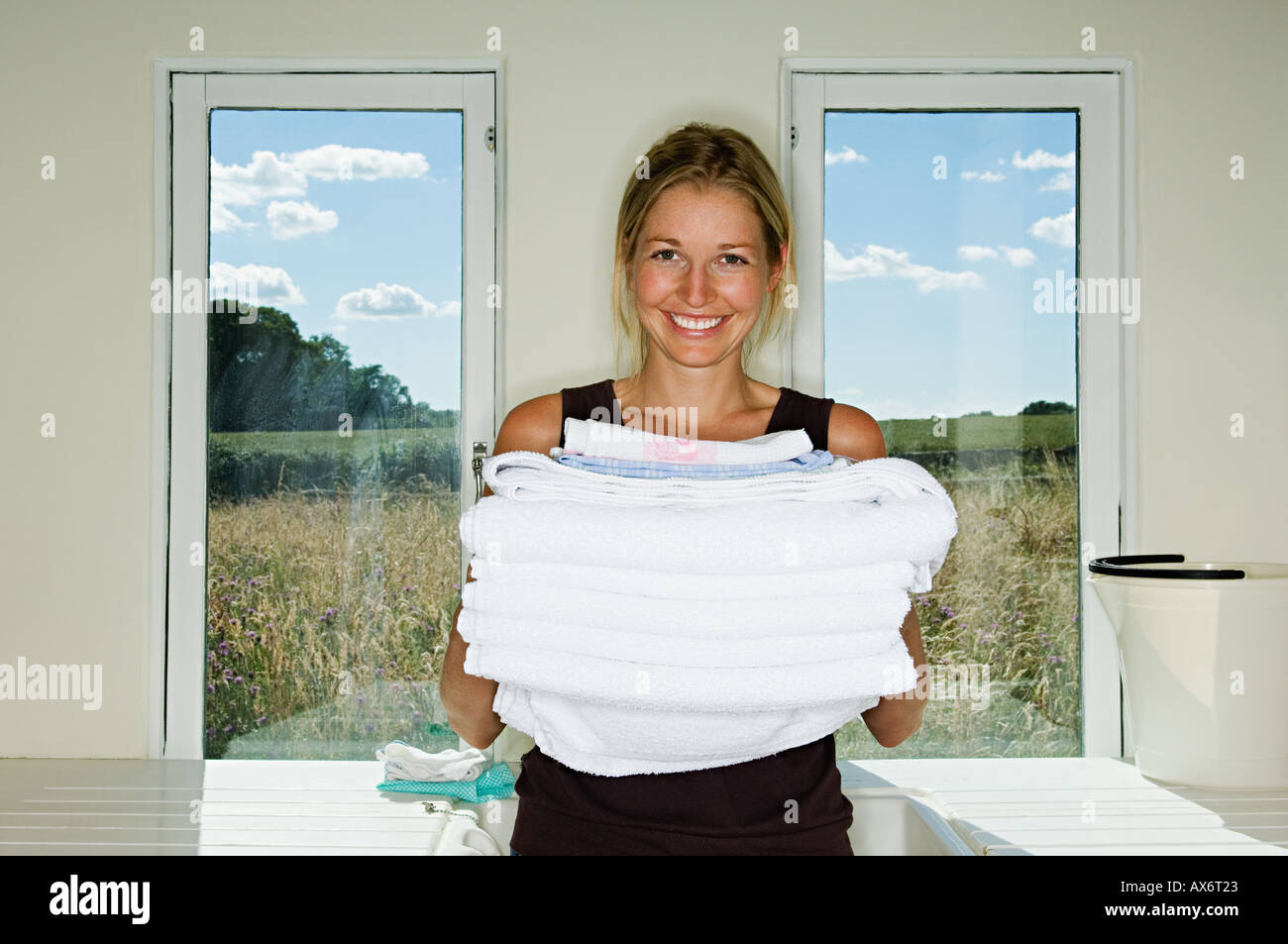 Woman holding pile of towels Stock Photo - Alamy