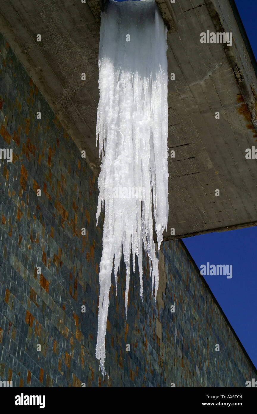 Huge icicle hanging from hole in roof Stock Photo - Alamy
