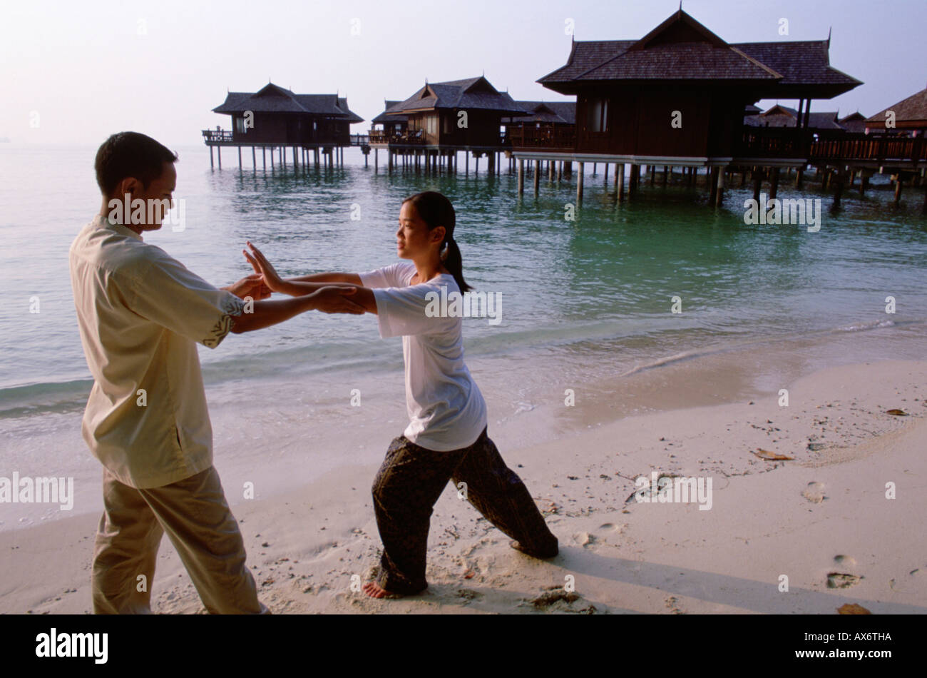 A woman practices Tai Chi Tai Qi on the beach of the Pangkor Laut ...