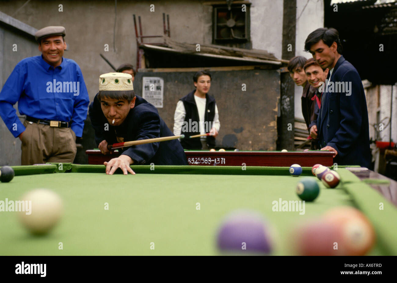 Uygur muslims in Beijing play a game of pool or billiards in the back ...