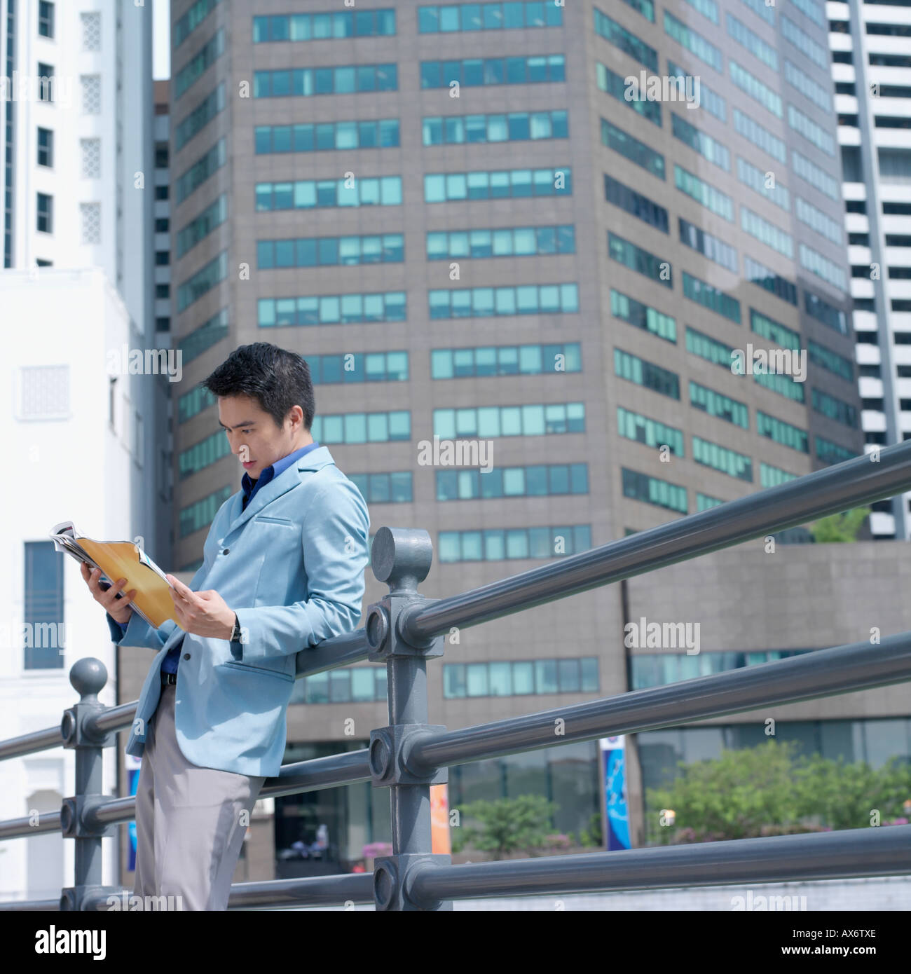 Side profile of a businessman reading a magazine Stock Photo - Alamy