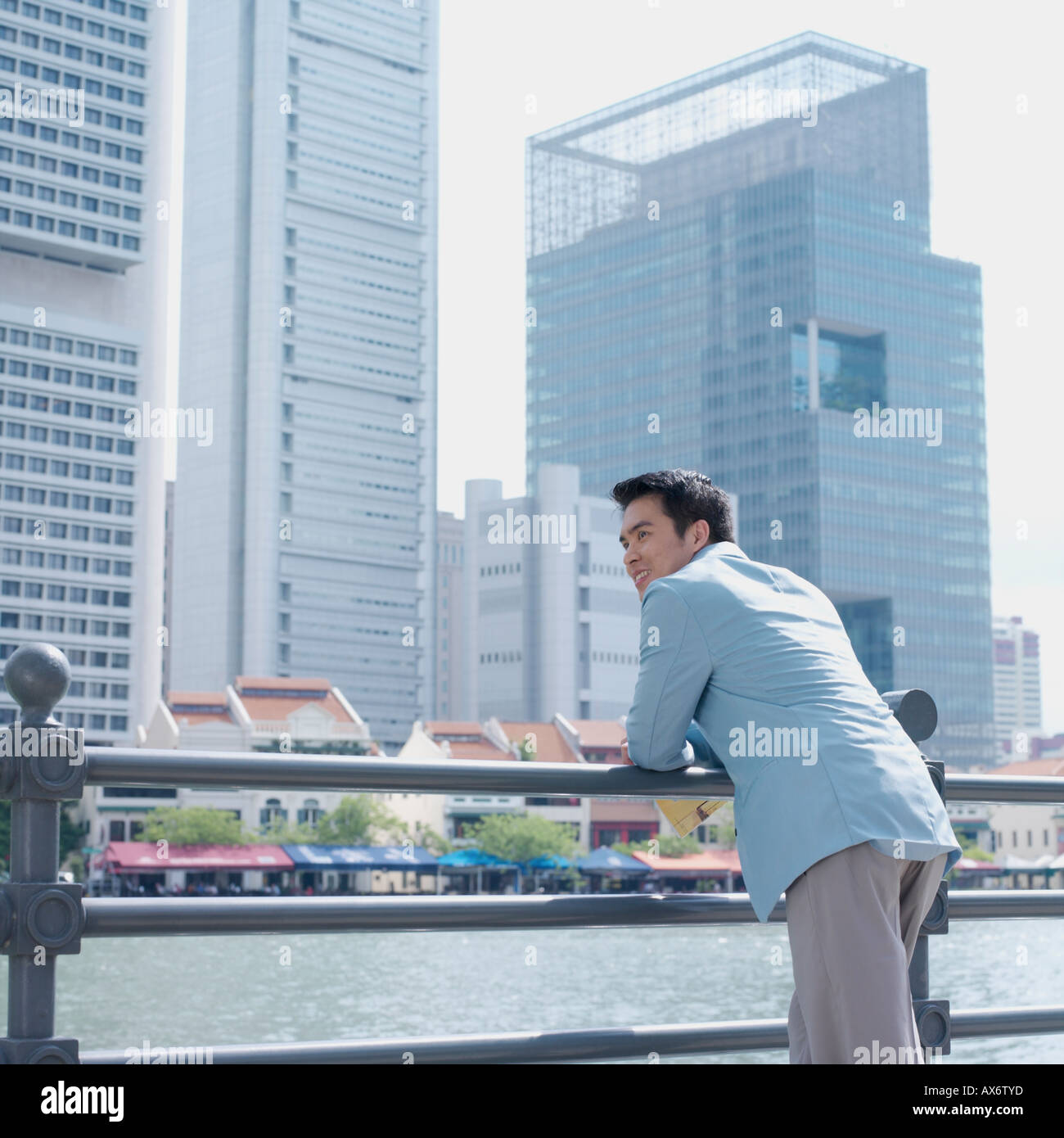 Rear view of a businessman leaning over a railing Stock Photo - Alamy