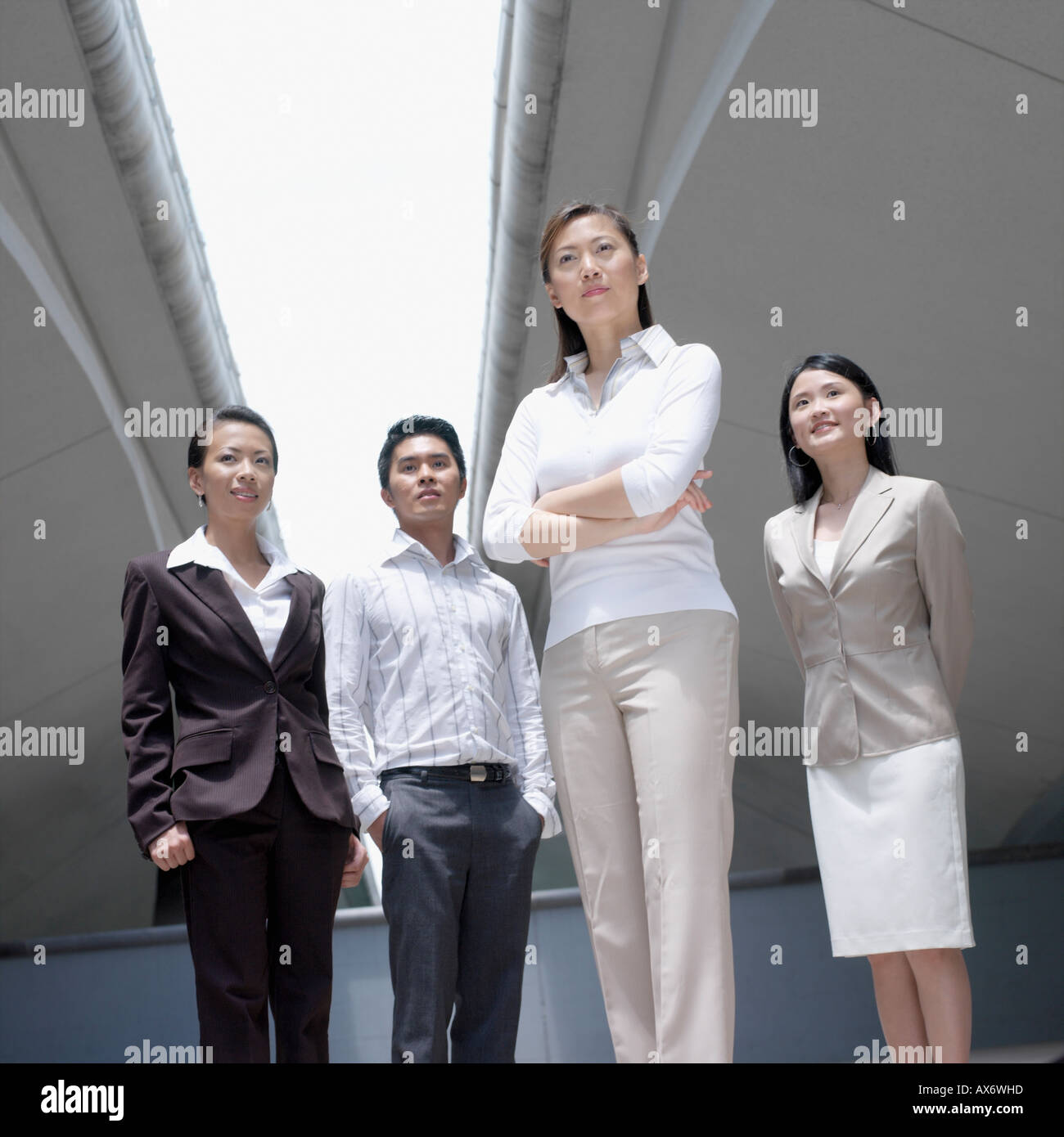 Low angle view of a businessman standing with three businesswomen Stock ...