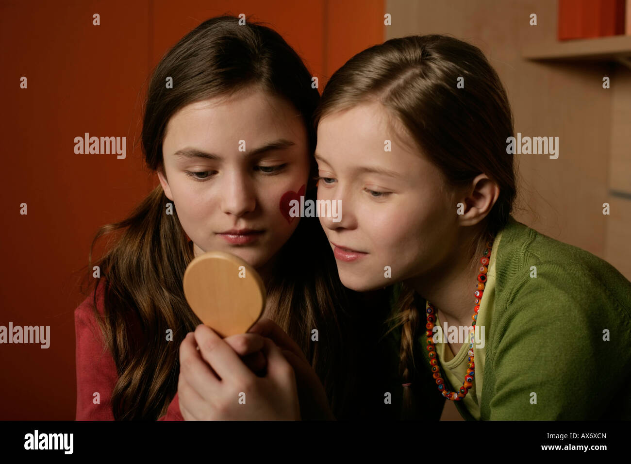 Two friends looking into a mirror Stock Photo - Alamy