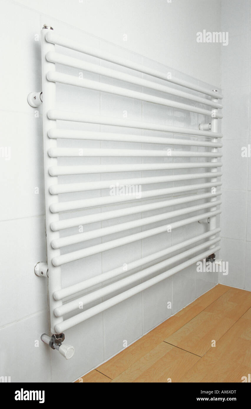White bathroom towel radiator on white tiled wall Stock Photo - Alamy