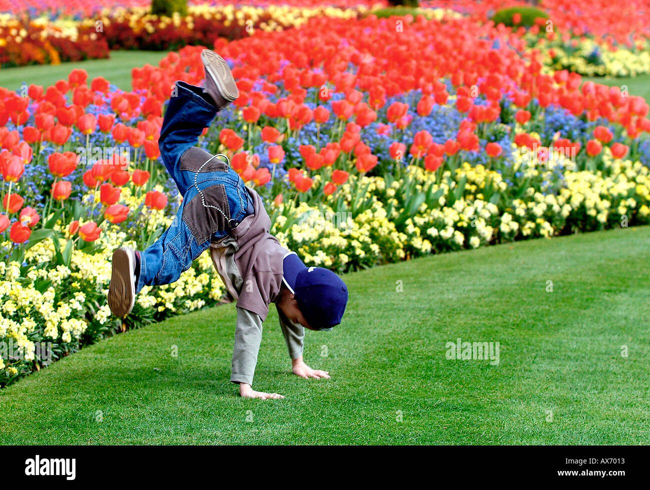 A young boy does a cartwheel while playing in on The Mall, London SW1 ...