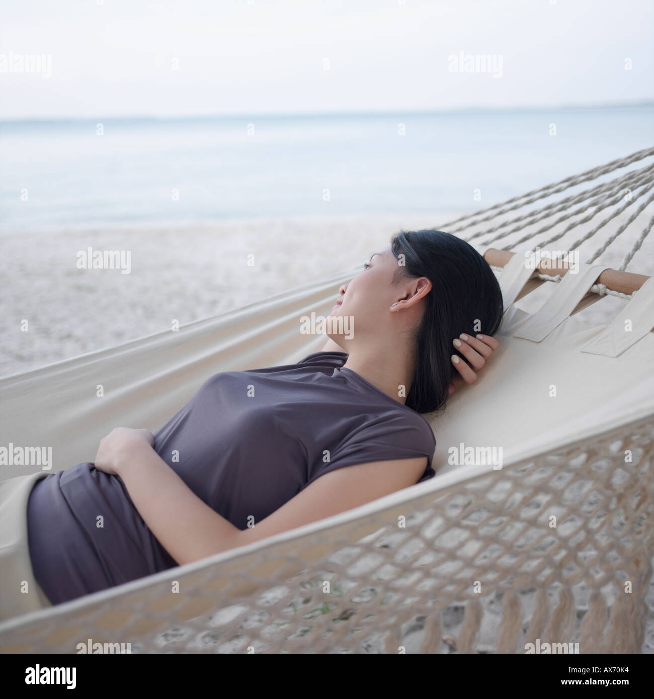 Side profile of a young woman relaxing in a hammock Stock Photo - Alamy