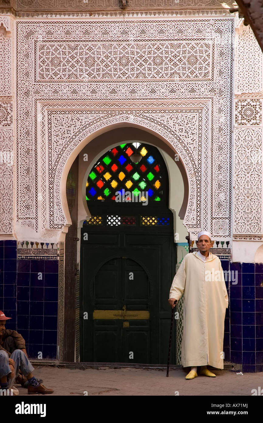 Old man with white jellaba stand near the front door of a mosque in the ...