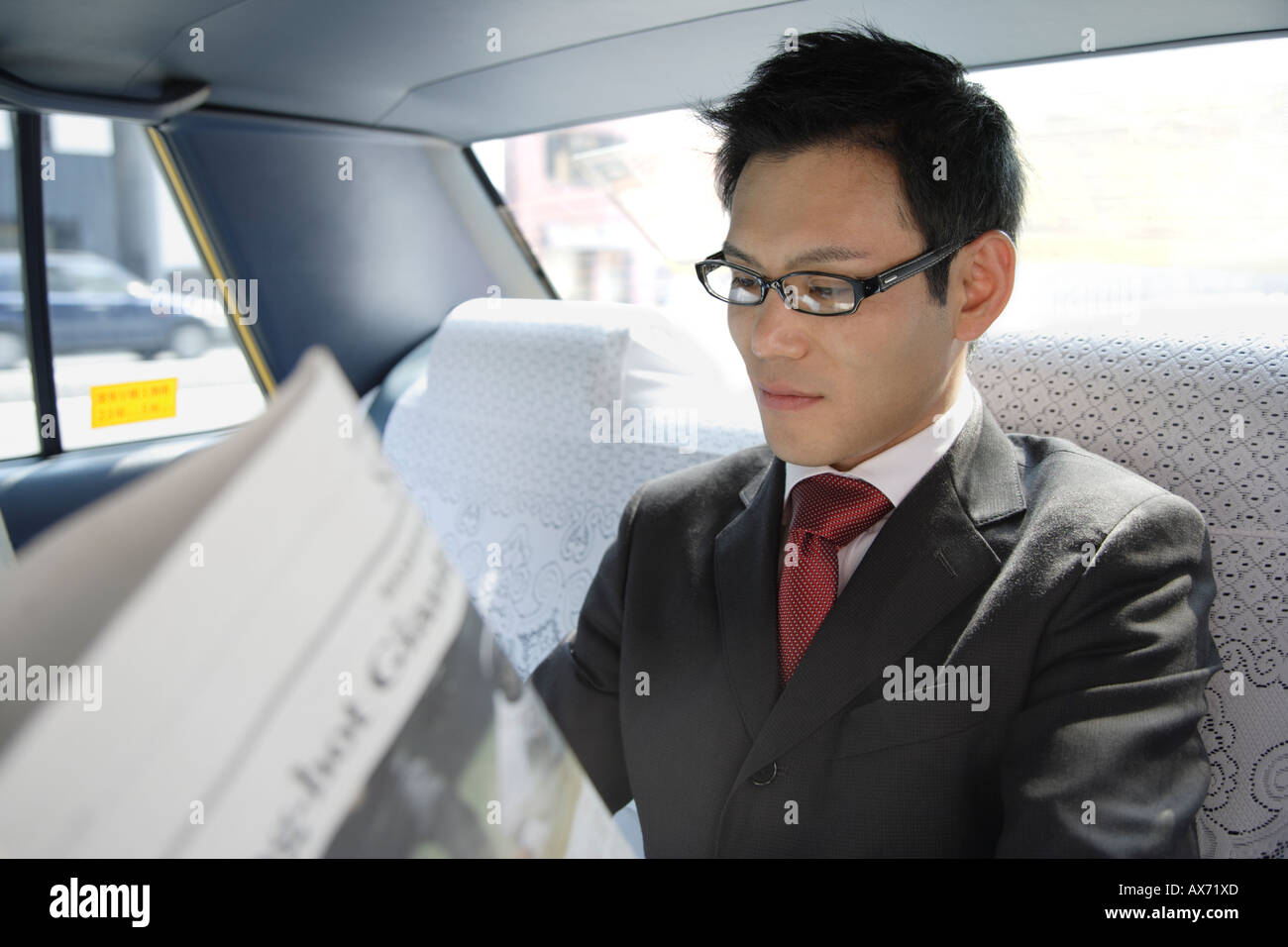 Businessman reading a newspaper in a car, portrait Stock Photo - Alamy