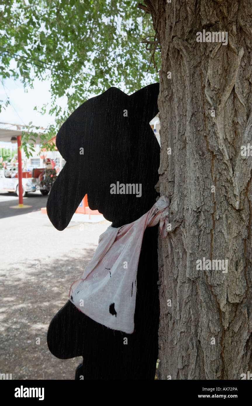 Cutout silhouette of a cowboy, leaning against a shady tree. Seligman ...