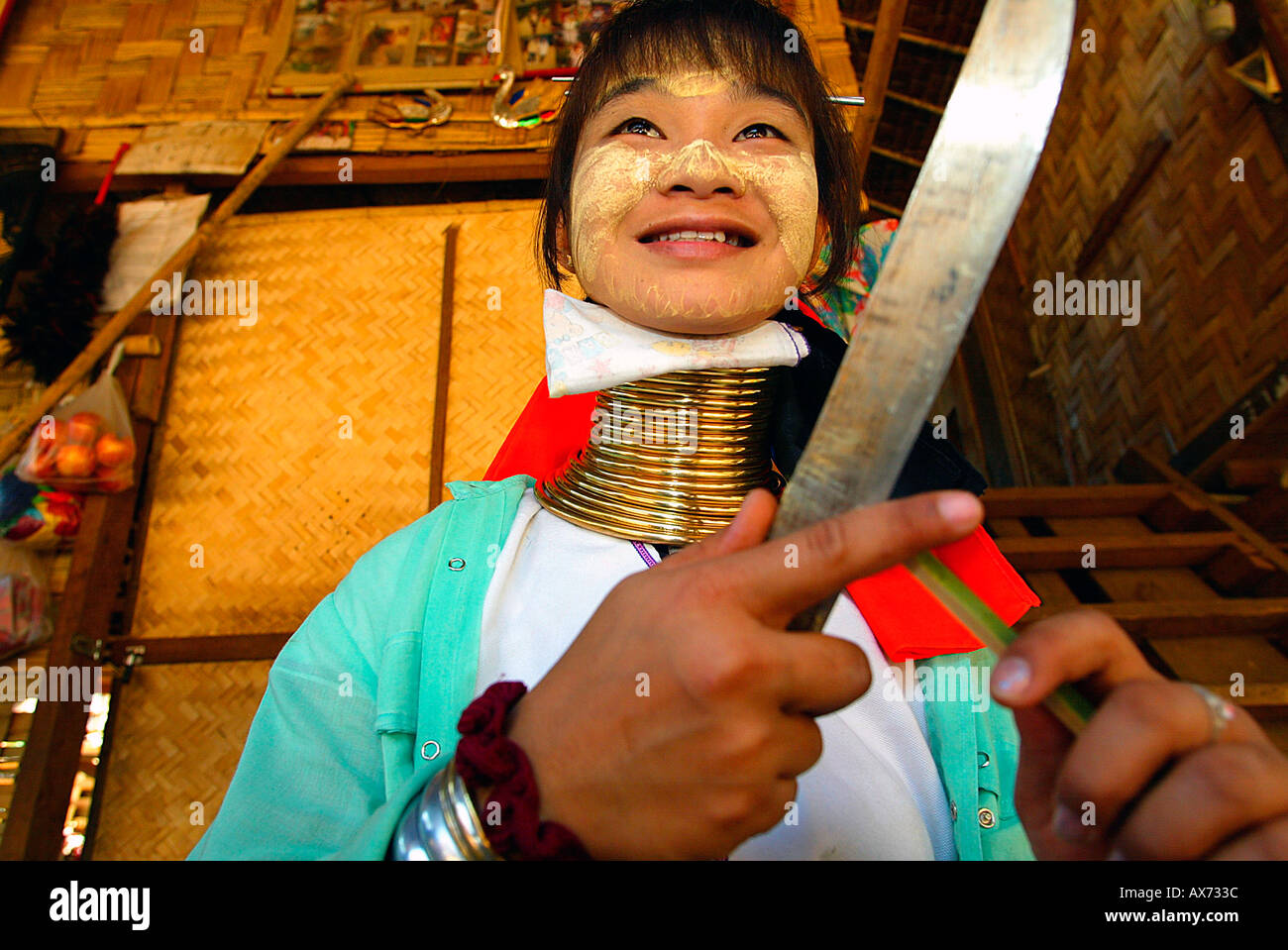 Hilltribe woman with machete trims palm frond for house's new roof ...