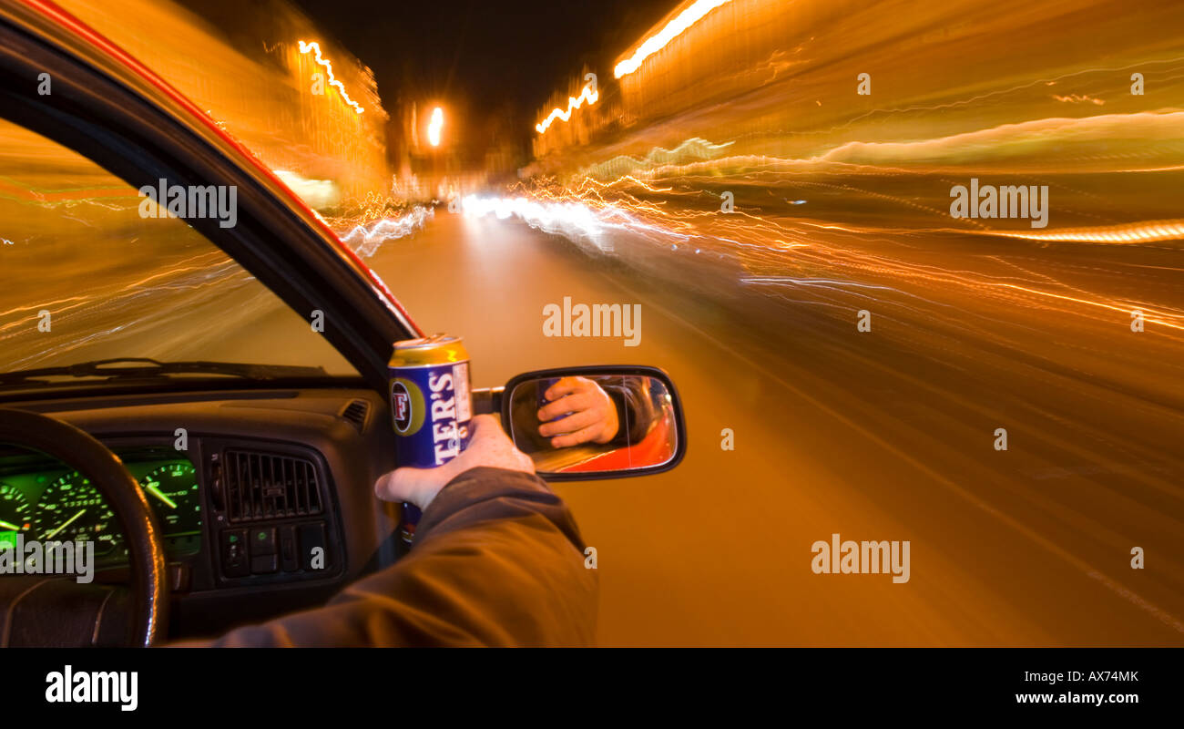 drink-driving, driving at night whilst holding a can of beer, showing ...