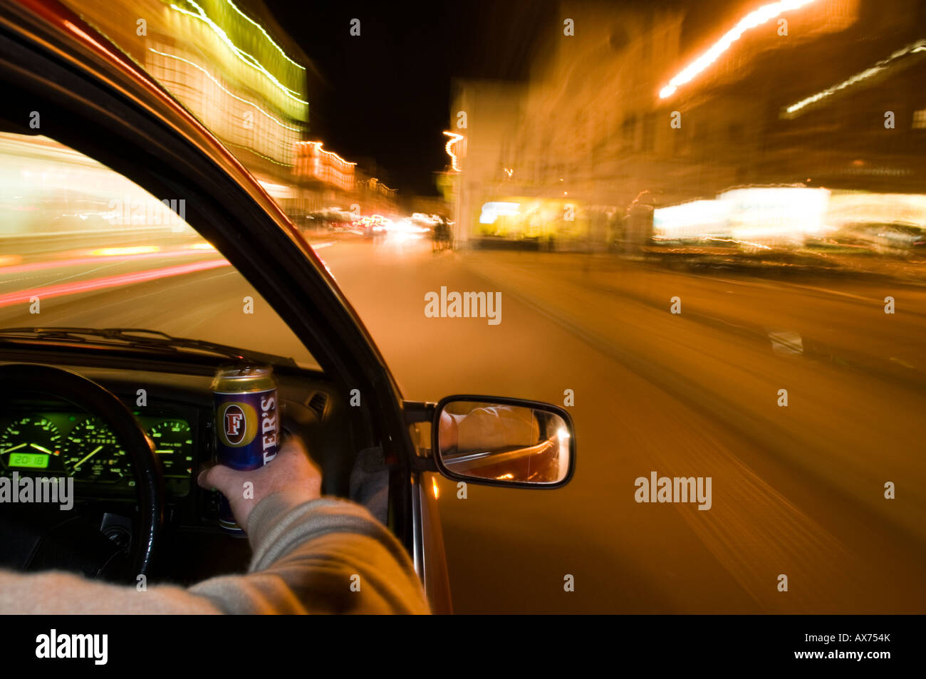 drink-driving, driving at night whilst holding a can of beer, showing ...