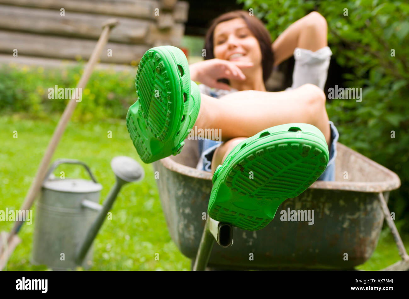 Young woman relaxing in wheelbarrow, portrait Stock Photo - Alamy