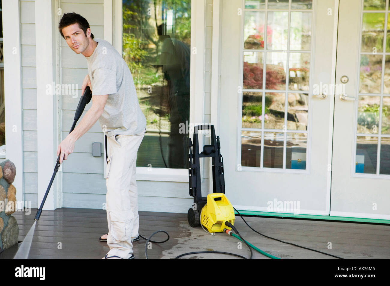 Portrait of a young man cleaning the porch of his house Stock Photo - Alamy