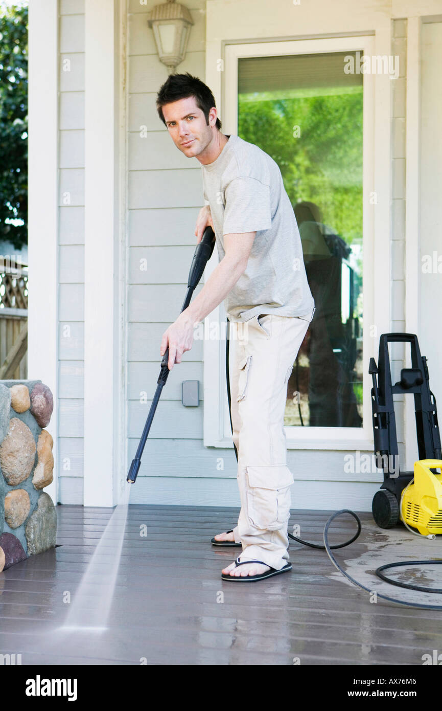Side profile of a young man cleaning the porch of his house Stock Photo ...