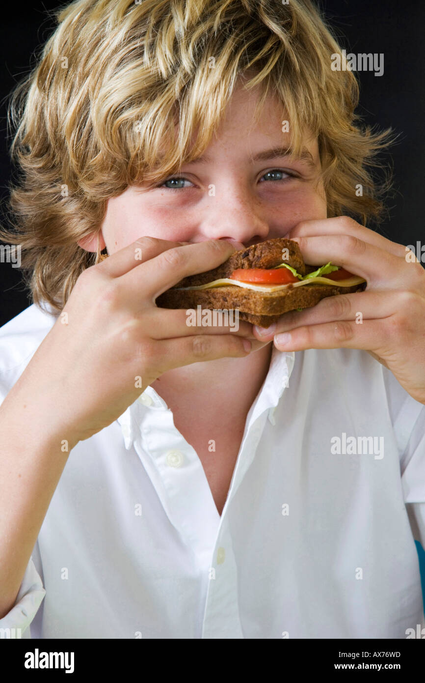 Portrait of a boy eating a sandwich Stock Photo - Alamy