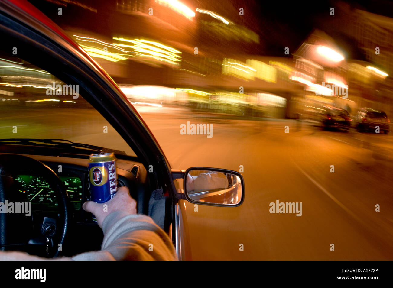 drink-driving, driving at night whilst holding a can of beer, showing ...